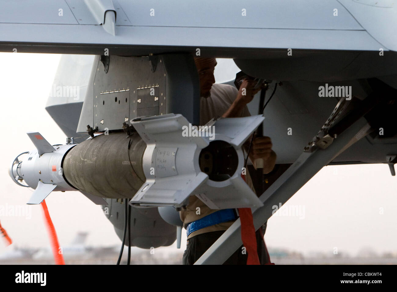 An aircrew member inspects the weapons loadout on an MQ-9 Reaper before ...