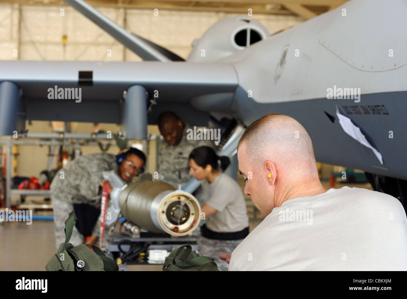 Senior Airman Jason Atwell operates a bomb lift while Staff Sgt ...