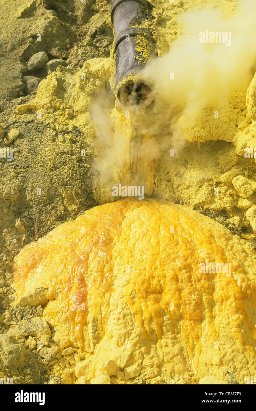 Condensated liquid sulphur running out of a pipe in Kawah Ijen Volcano ...