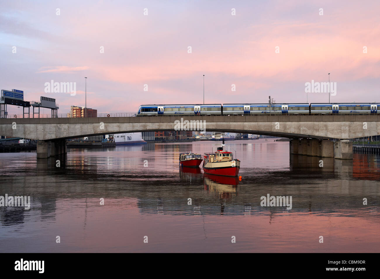 nir train crossing the lagan bridge over the river lagan at dusk ...