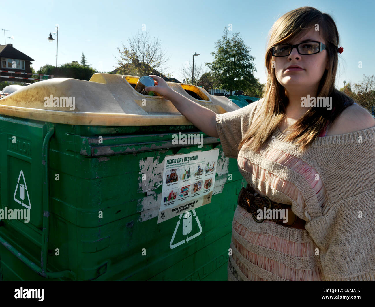 Woman Putting Can In Recycling Bank England Stock Photo - Alamy