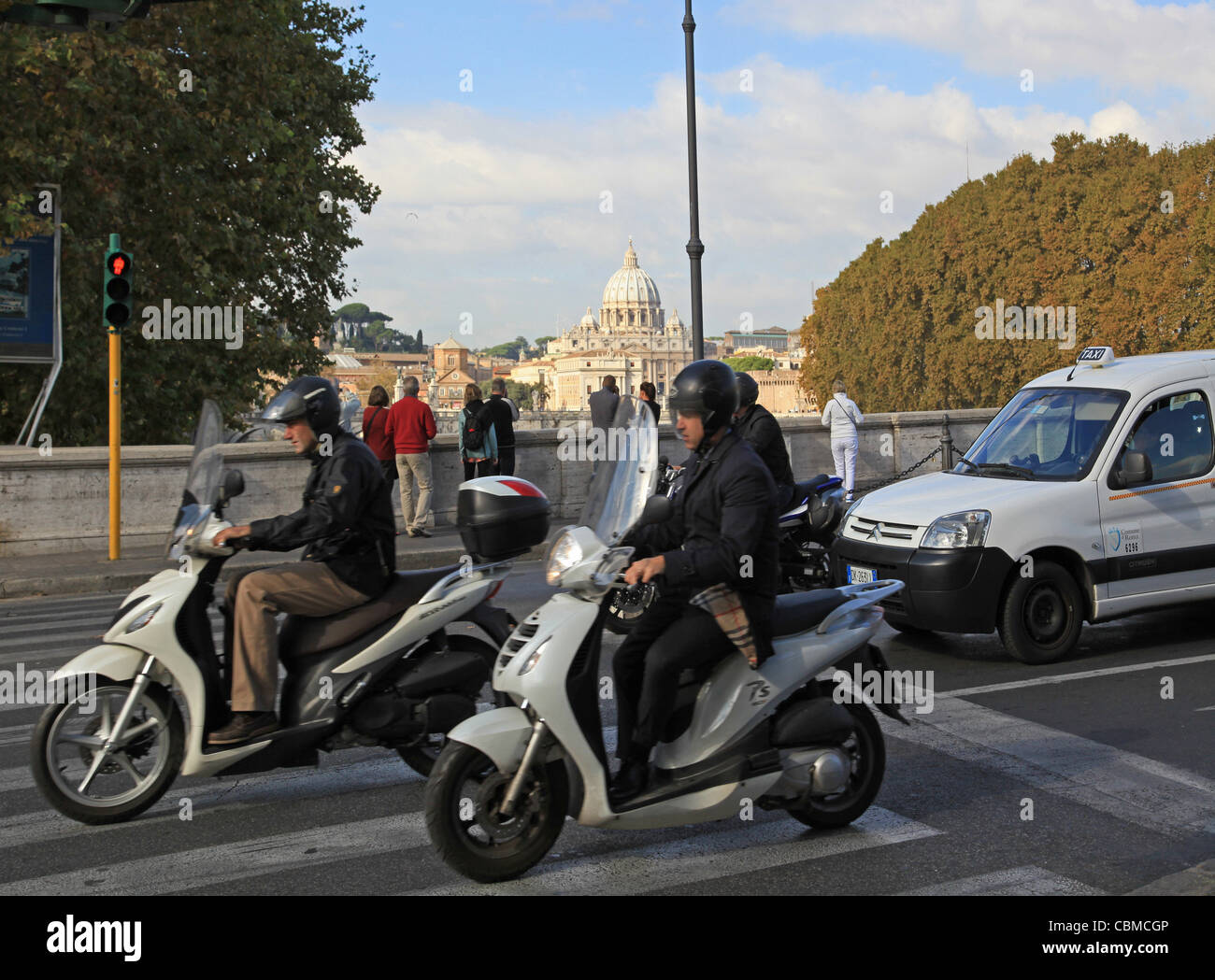 Roman street with motorcycle traffic and St. Peter's Basilica in the ...