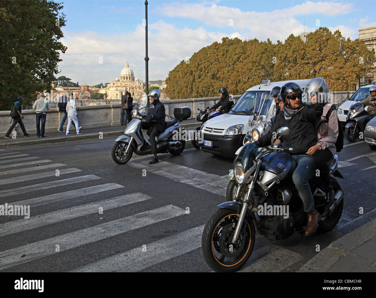 Roman street with motorcycle traffic and St. Peter's Basilica in the ...