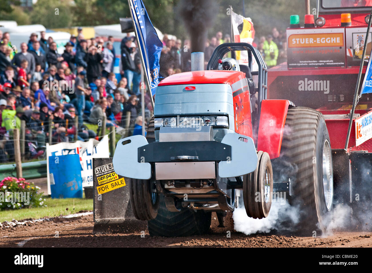 Exhaust smoke and steam erupt from a competitor in a tractor pulling ...