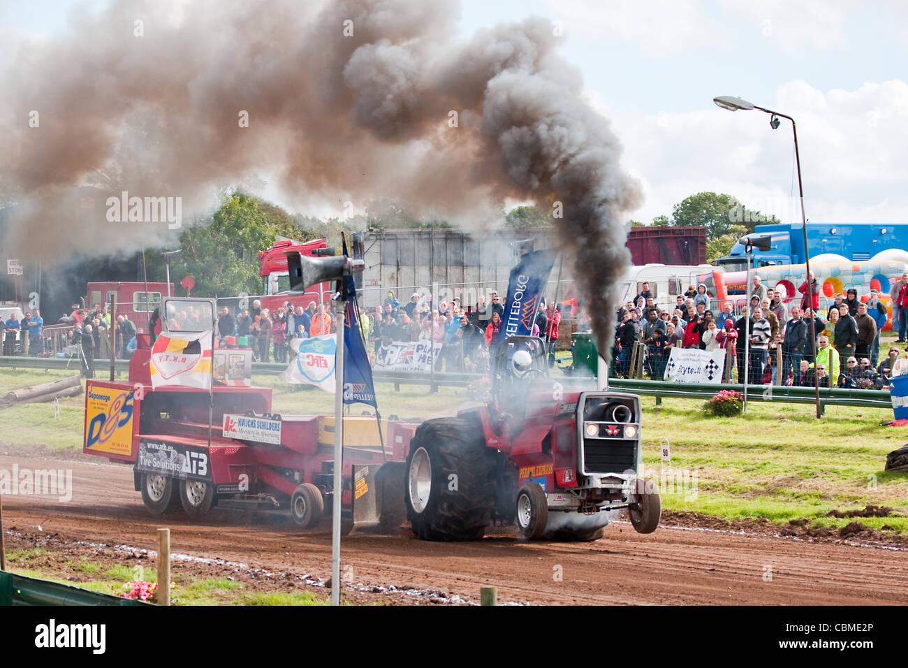Smoke and steam erupting from a competitor in a tractor pulling contest ...