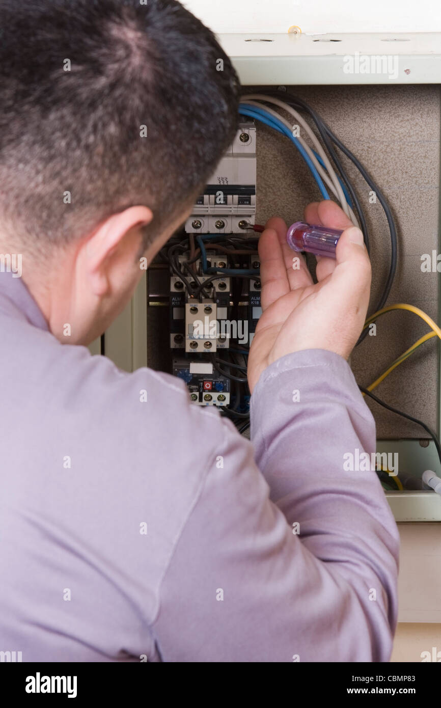 Electrician working on a panel Stock Photo - Alamy