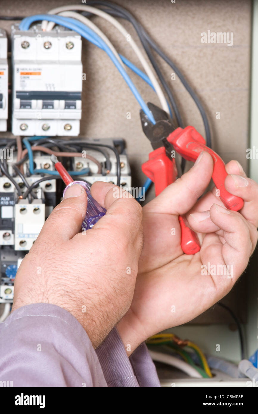 Electrician working on a panel Stock Photo - Alamy