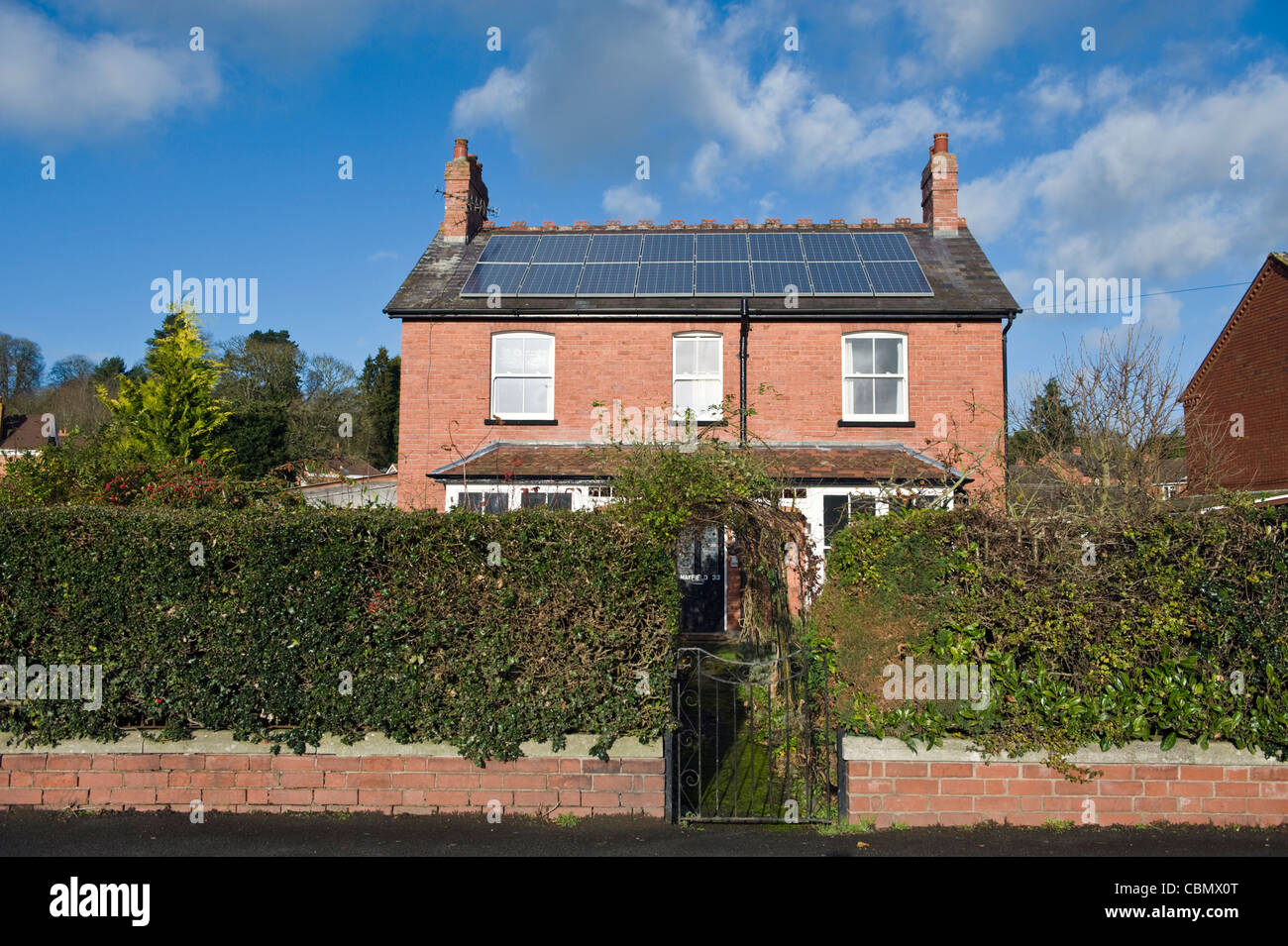 Solar panels on roof of detached red brick period house in Kington ...