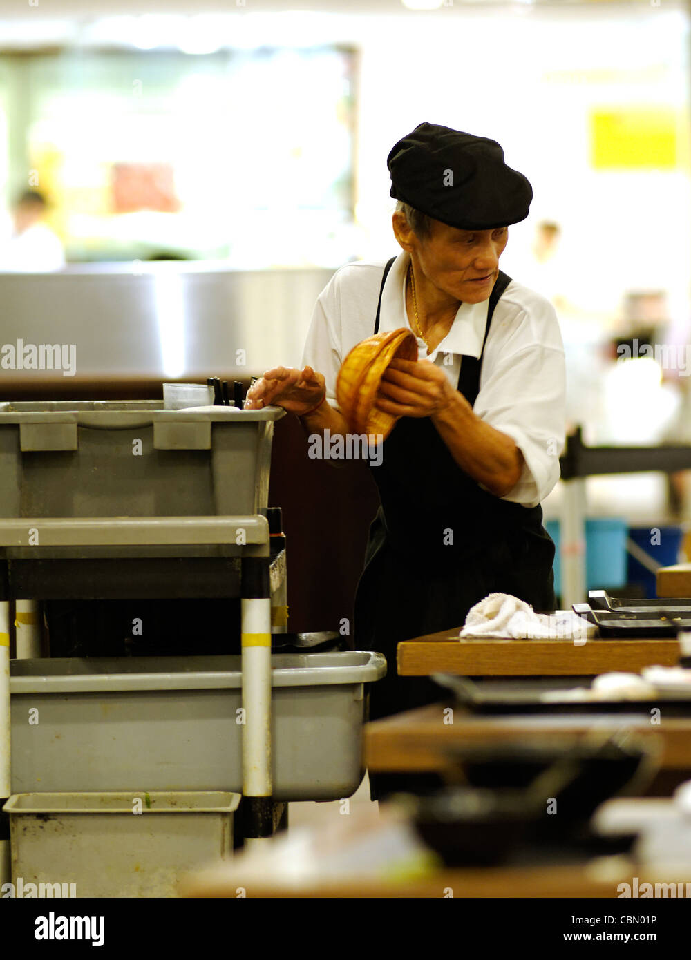 Man collecting used dishes and bowls in a Singapore food hall Stock ...