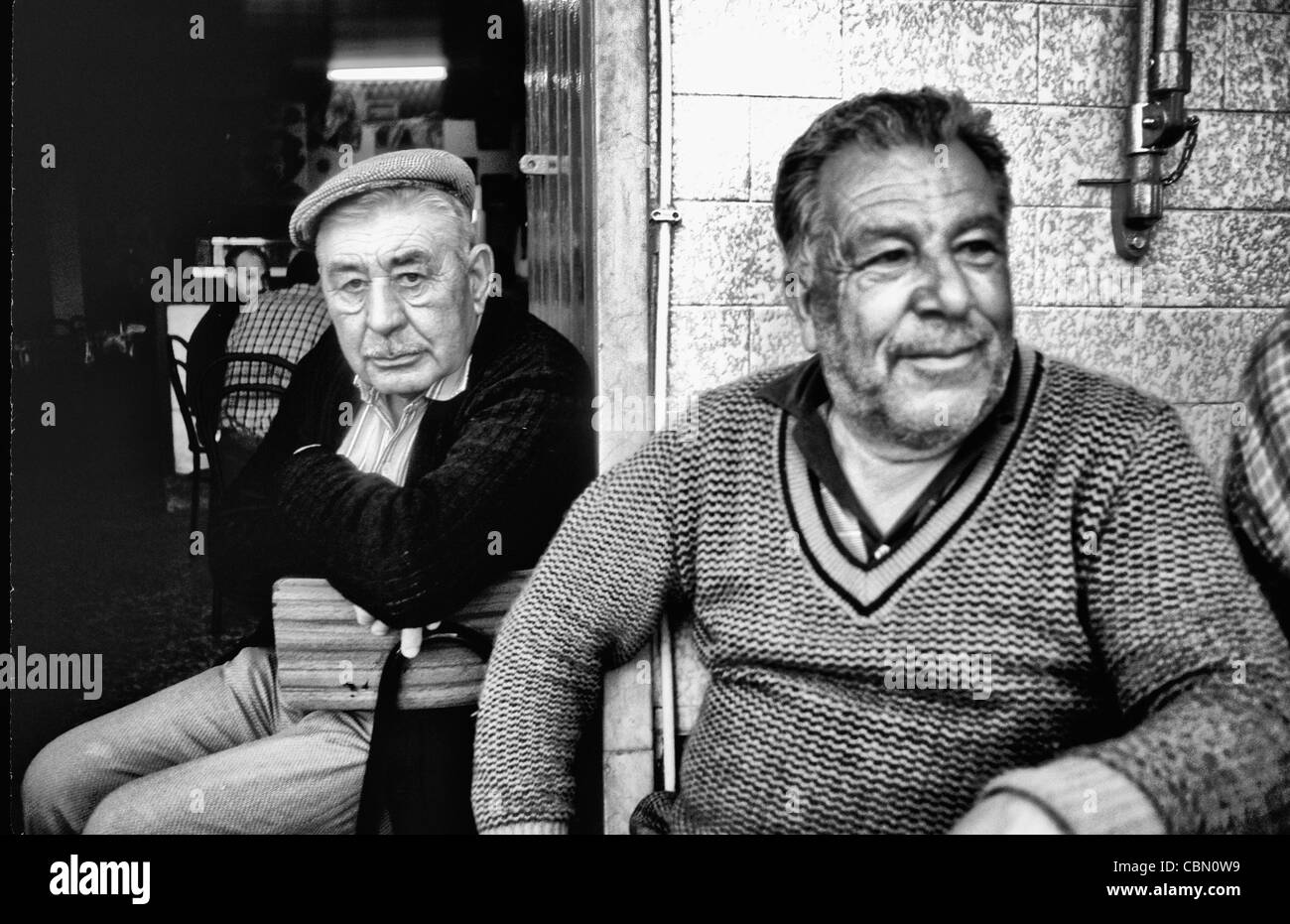 Tough and rough old fishermen relaxing at a bar in the village of Olmao ...