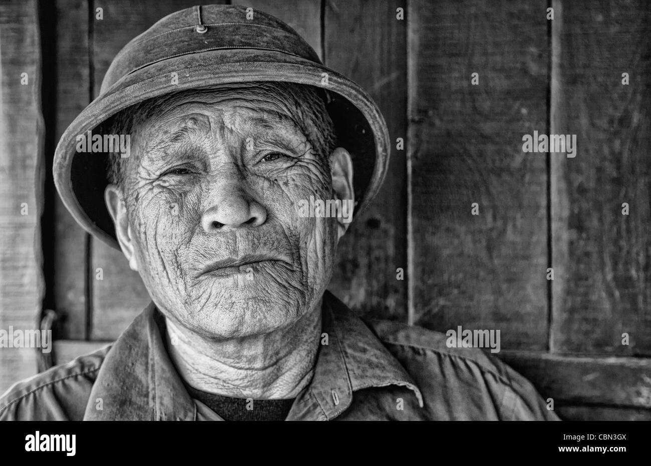 Picturesque scene old man in helmet fishing village Halong Bay Ha Long ...