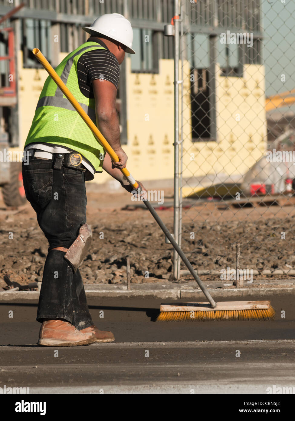 Construction worker leveling a new cement road Stock Photo - Alamy