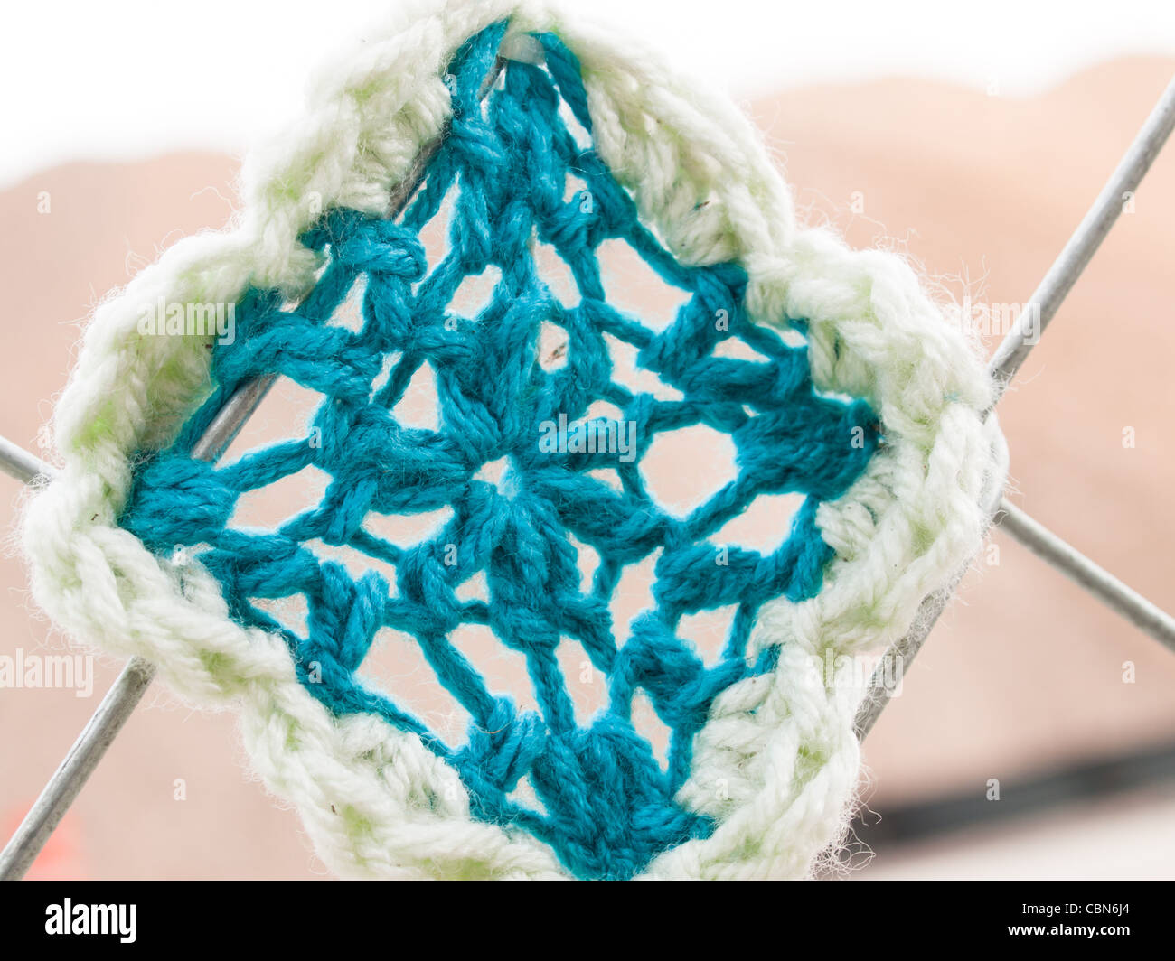 Construction fence covered with crocheted garden creatures like bugs ...