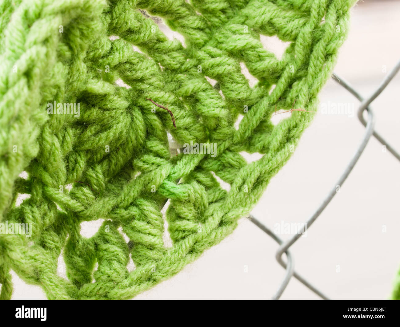 Construction fence covered with crocheted garden creatures like bugs ...