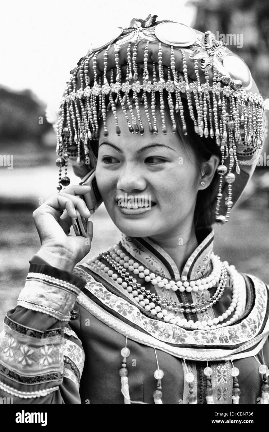 Local woman in traditional costume having communication with cell phone ...