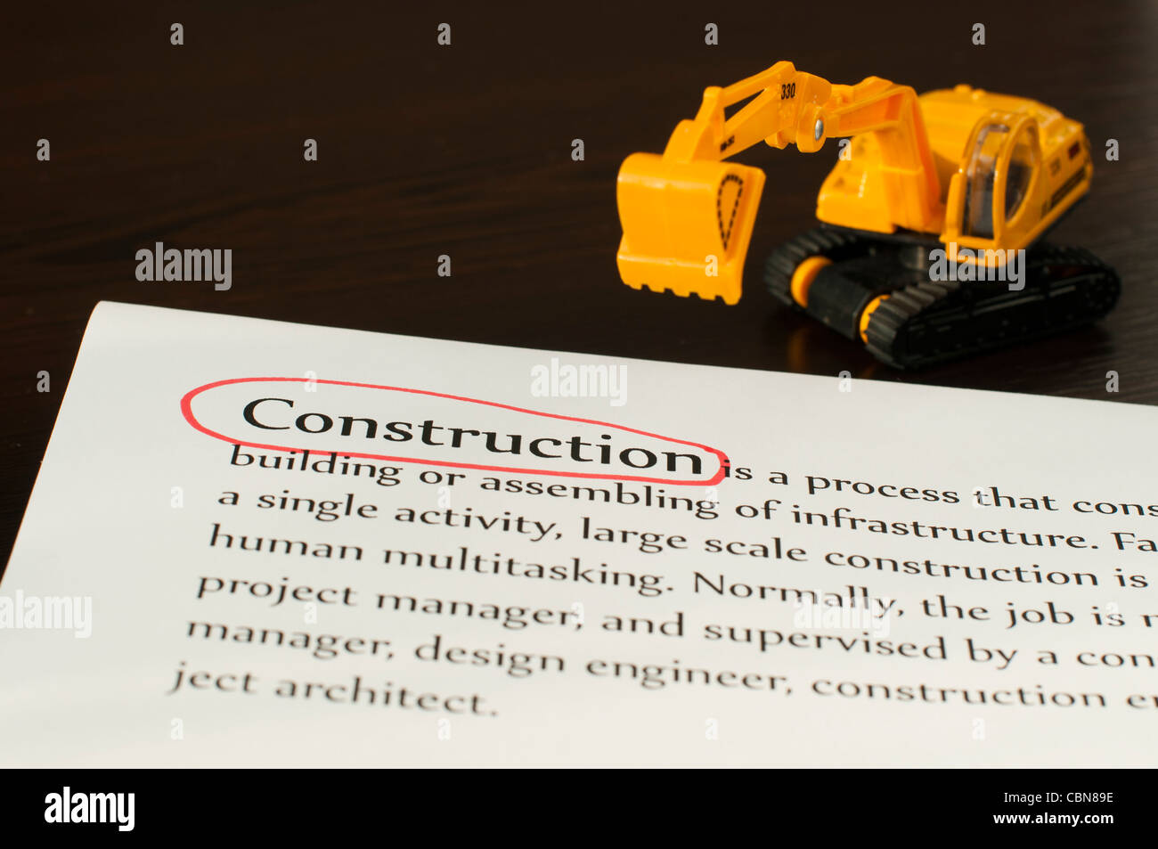 Construction concept. Paper,text and excavator Stock Photo - Alamy