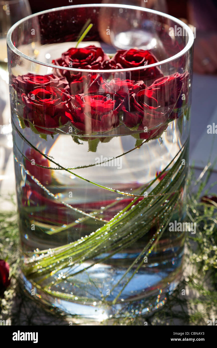 Vase with red roses floating on water as a table decoration Stock Photo ...