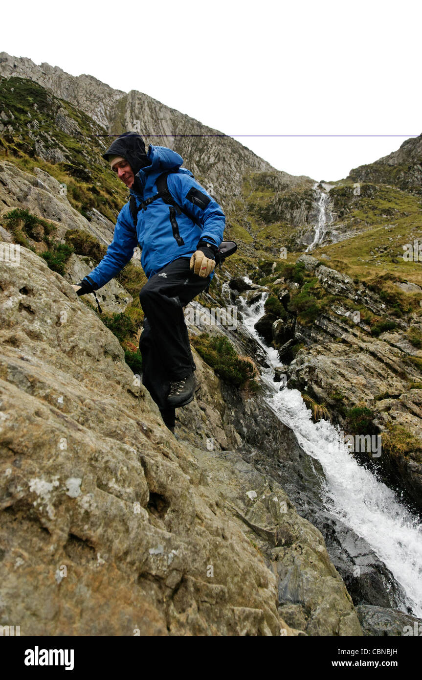 A walker crossing Idwal stream Cwm Idwal Stock Photo - Alamy