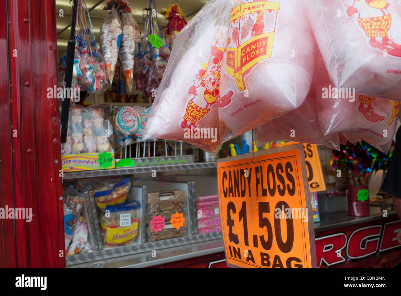 Bags of pink candy floss for sale in front of sweet stall / van at fair ...