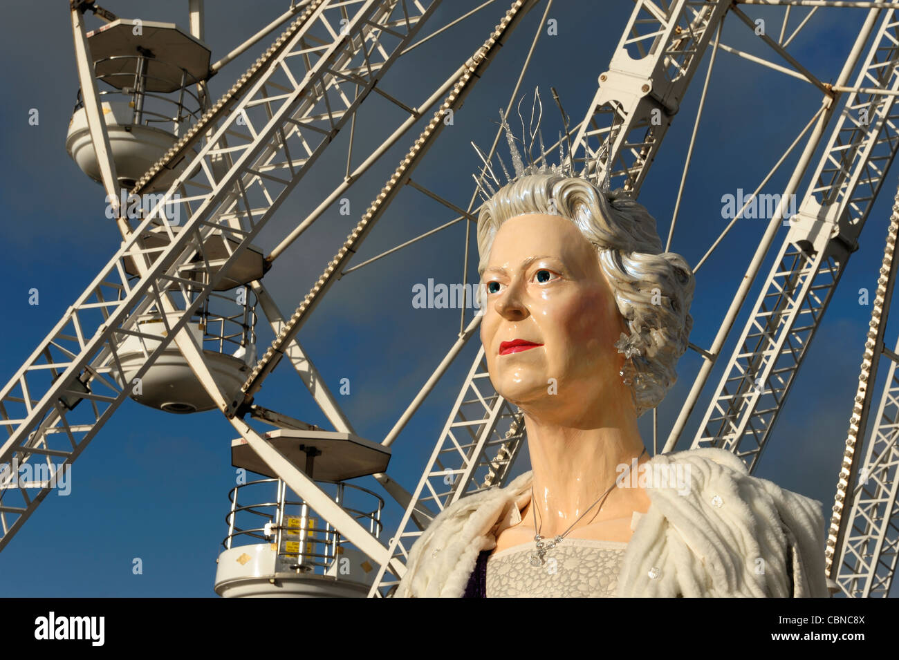 A giant statue of Queen Elizabeth in front of a ferris wheel in Chester ...