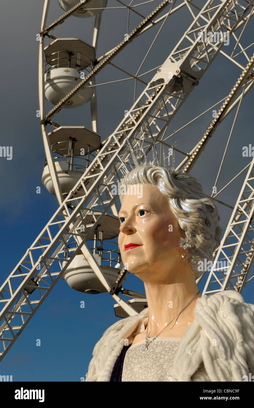A giant statue of Queen Elizabeth in front of a ferris wheel in Chester ...