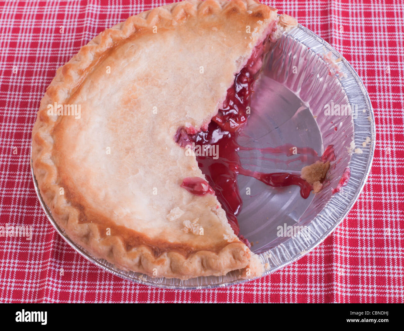 Cherry pie in baking tin with piece missing Stock Photo - Alamy