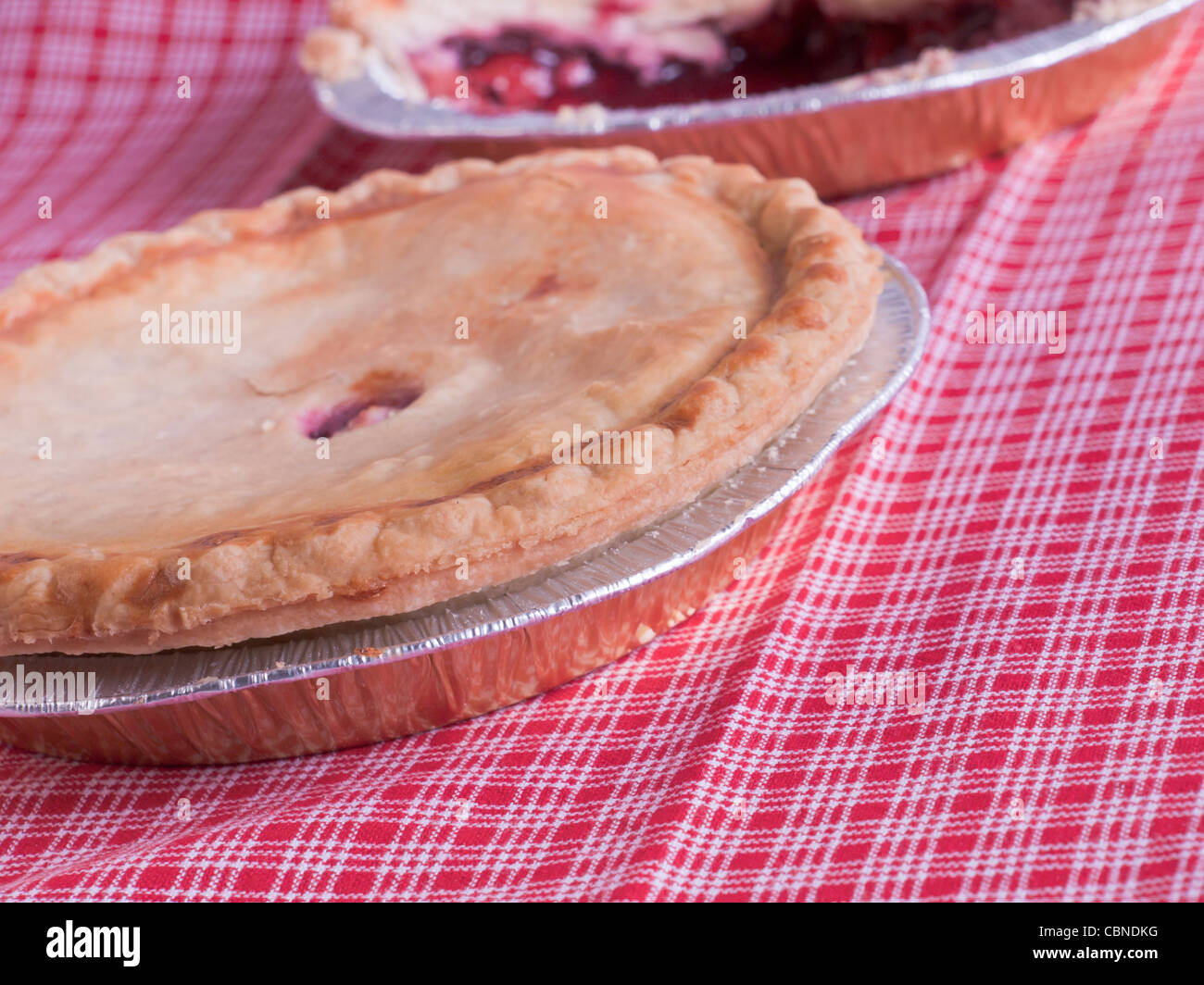 Cherry pie in baking tin with piece missing Stock Photo - Alamy