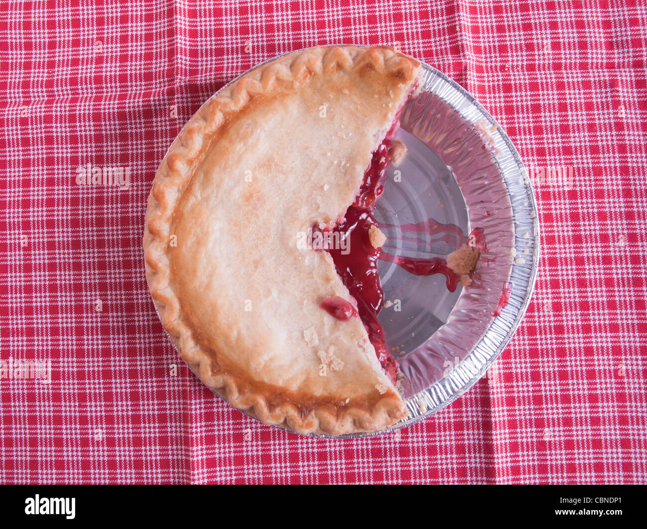 Cherry pie in baking tin with piece missing Stock Photo - Alamy