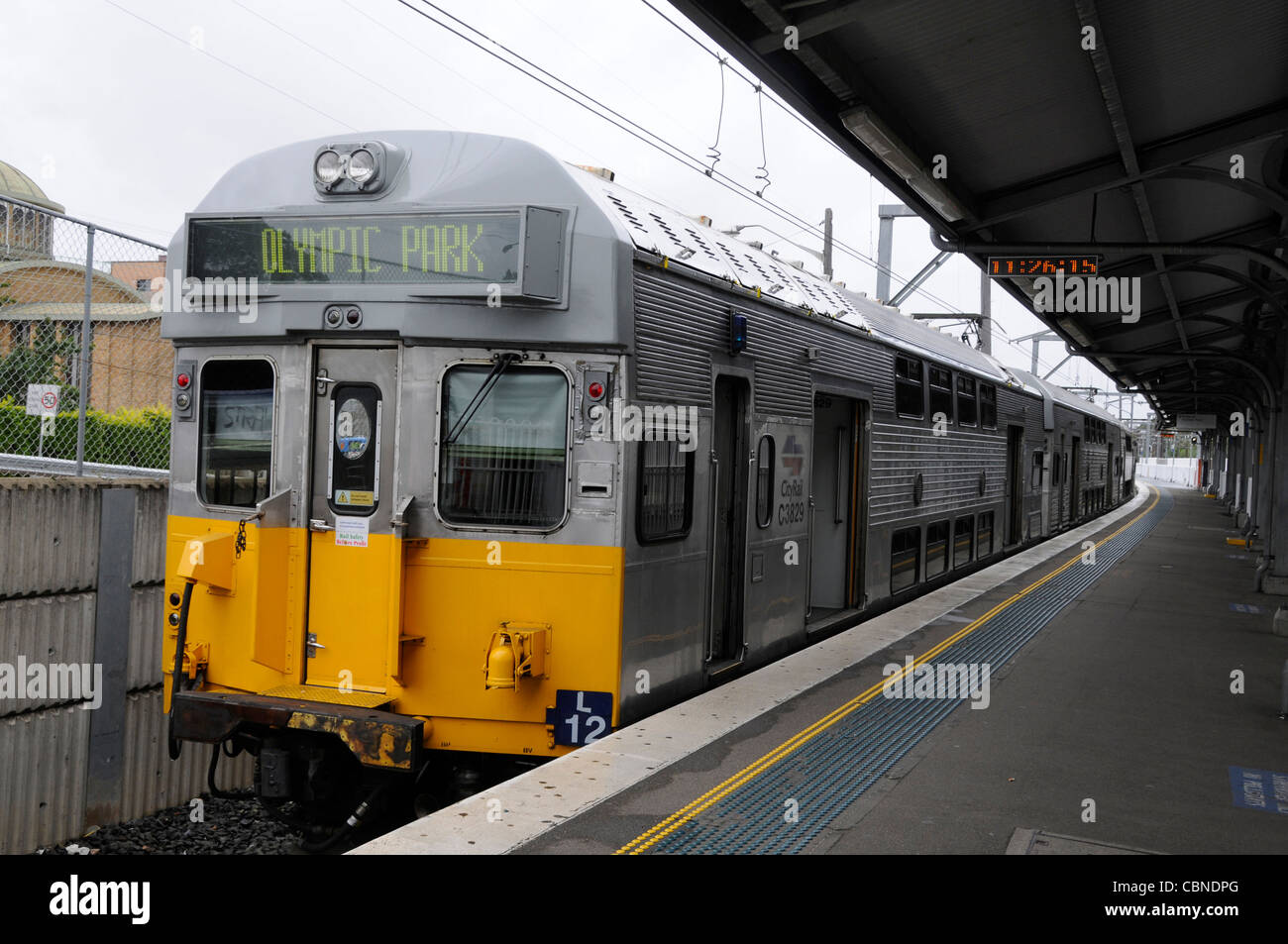 A local commuter train stops at Olympic Park Station in the suburbs of ...