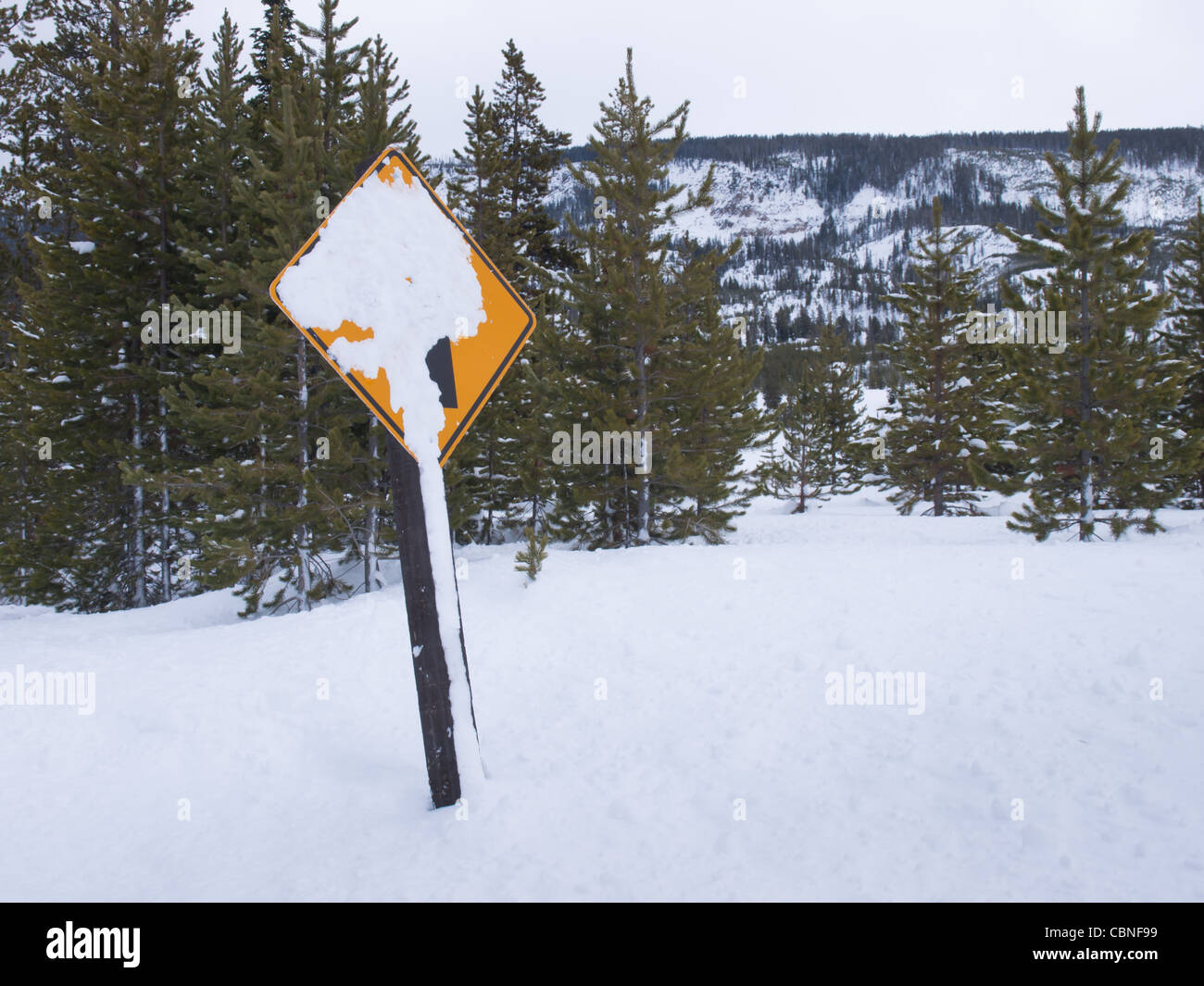 Yellow road sign covered in snow at the Great Teton national park Stock ...