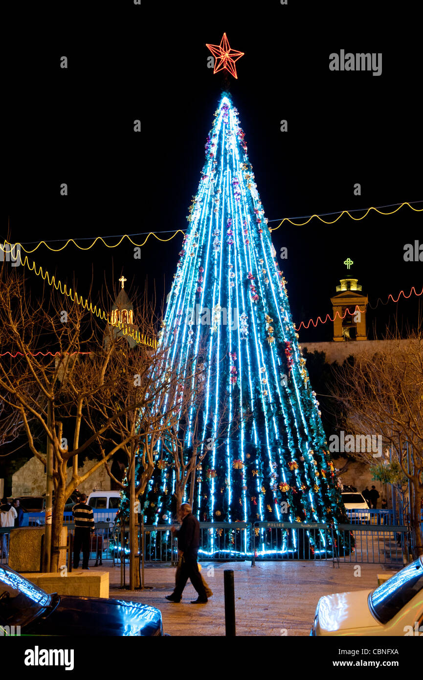A Christmas tree illuminates passers-by in Manger Square near the ...