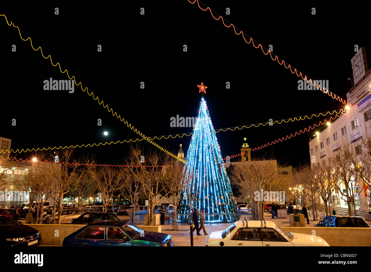 A Christmas tree illuminates passers-by in Manger Square near the ...