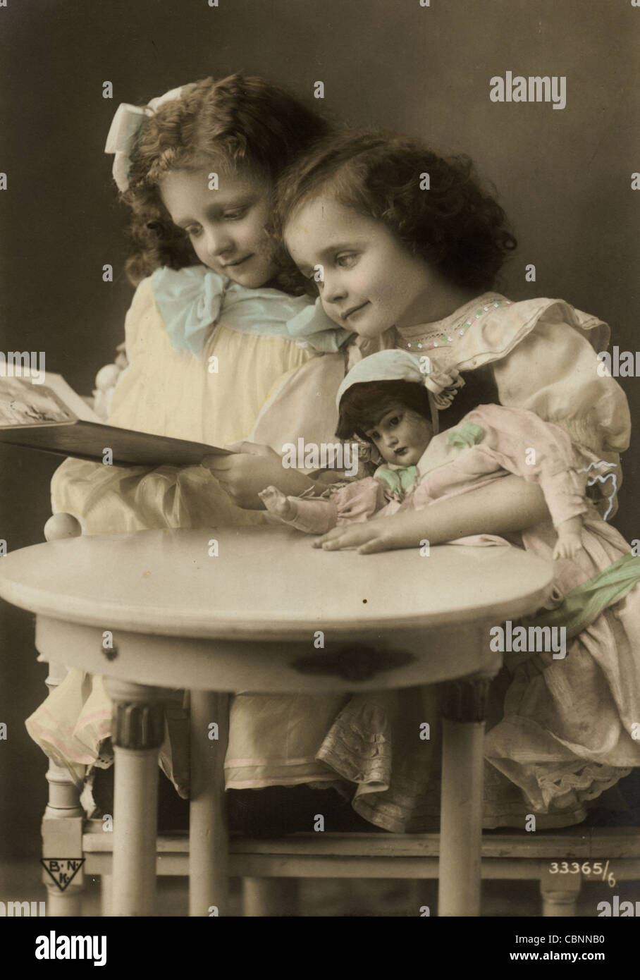 Two Adorable Little Girls Reading with Doll Stock Photo - Alamy