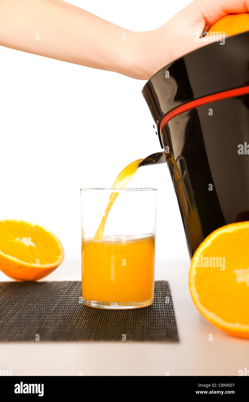 making orange juice from sliced oranges with help of juicer Stock Photo ...