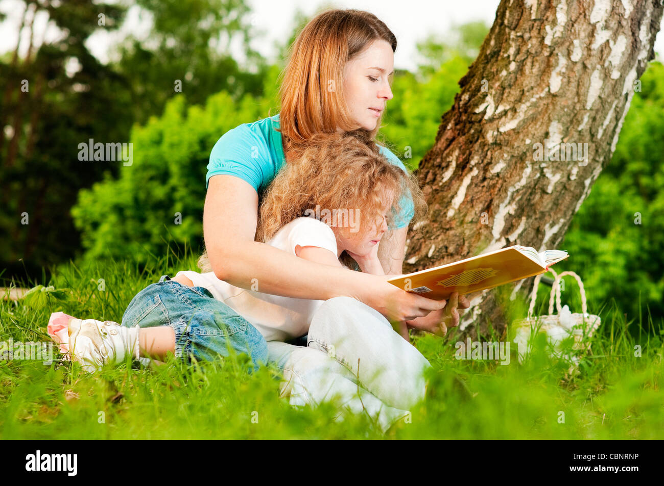 Happy girl lying under tree hi-res stock photography and images - Alamy