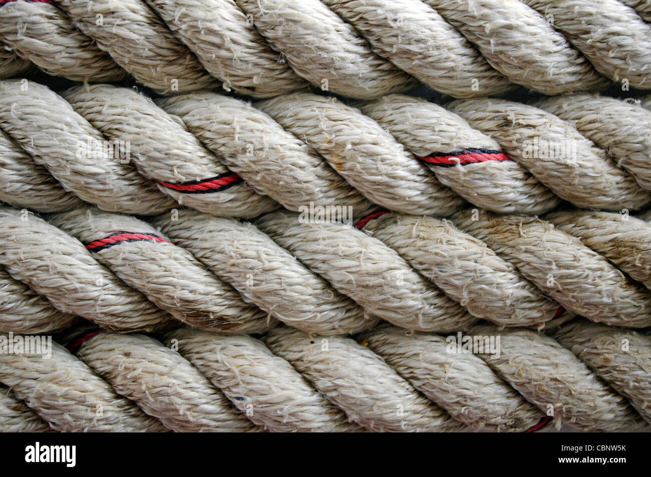 Four horizontal rows of thick twisted white marine rope Stock Photo - Alamy