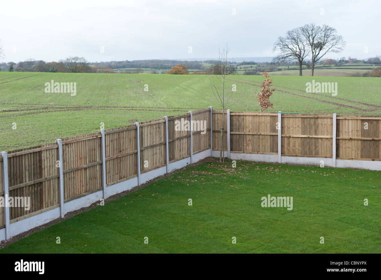 Wooden fences around the gardens of modern new homes built in a rural ...