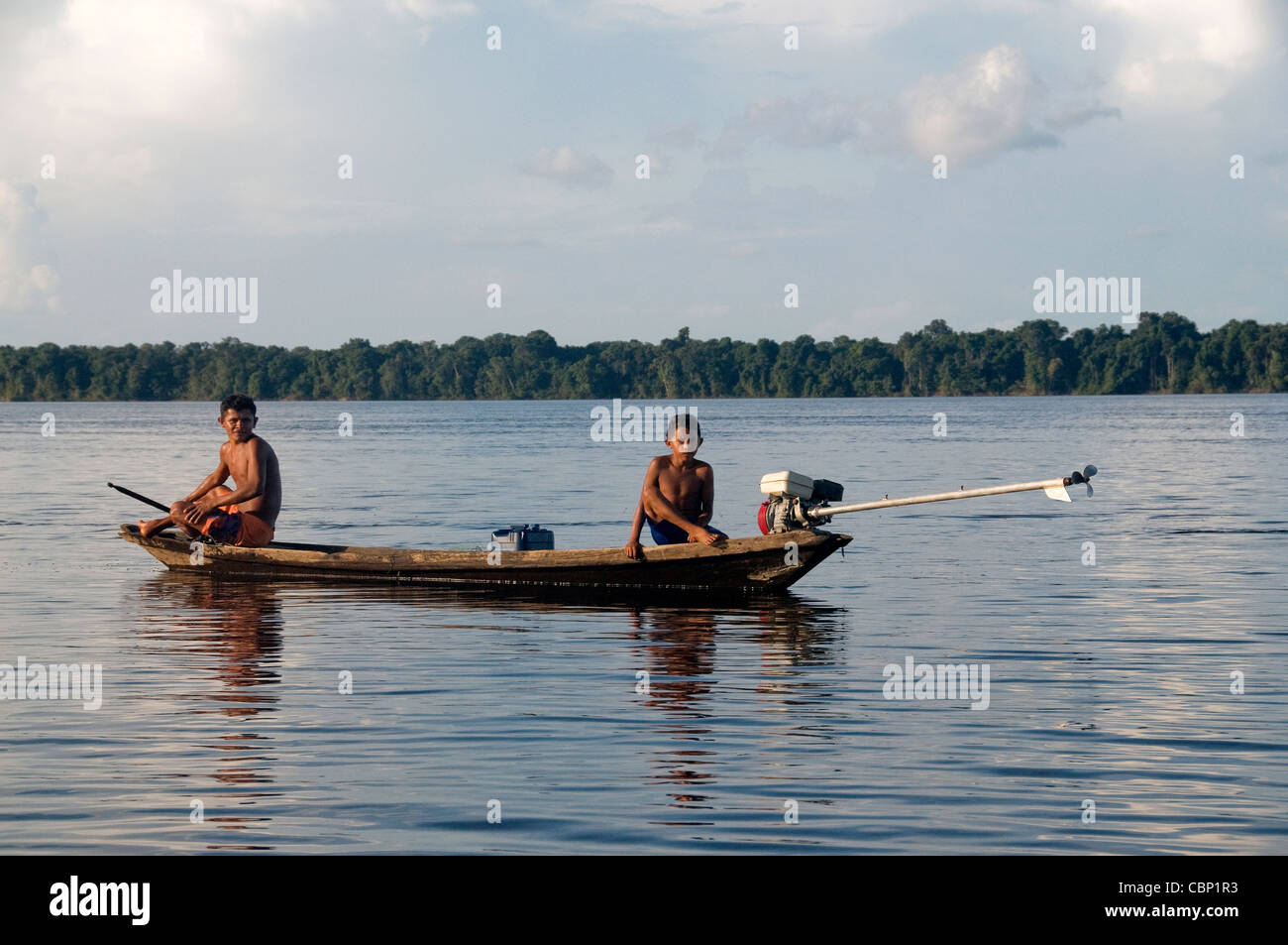 A couple of natives in a dugout canoe are fishing with nets on the Rio ...