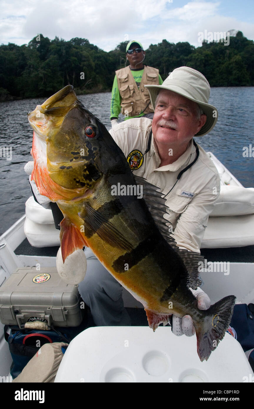 An angler and his guide admire a giant peacock bass caught on a ...