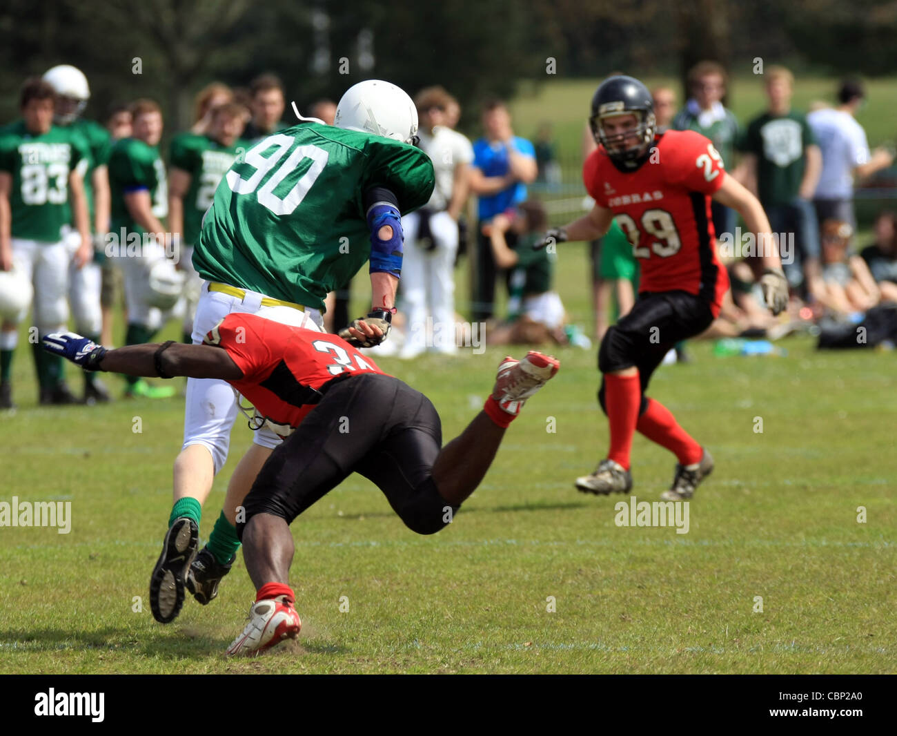 An American football player makes a diving tackle on a member of the ...
