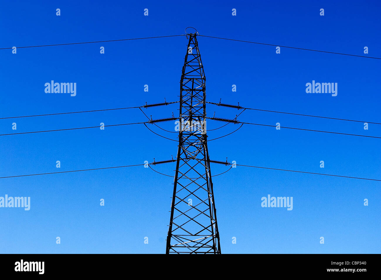 tall electric pylon and cables on blue sky background Stock Photo - Alamy