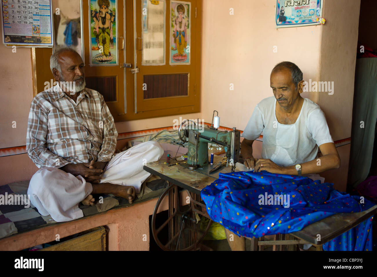 Indian man with old sewing machine making sari in Narlai village in ...