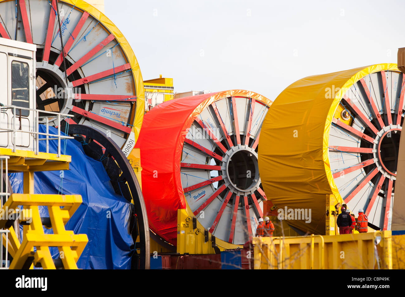 A crane lifting offshore cabling onto a ship at Duco Ltd, an offshore ...