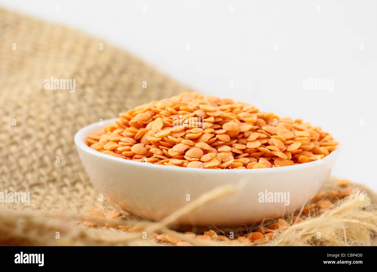 Bowl of red lentils on white background Stock Photo - Alamy