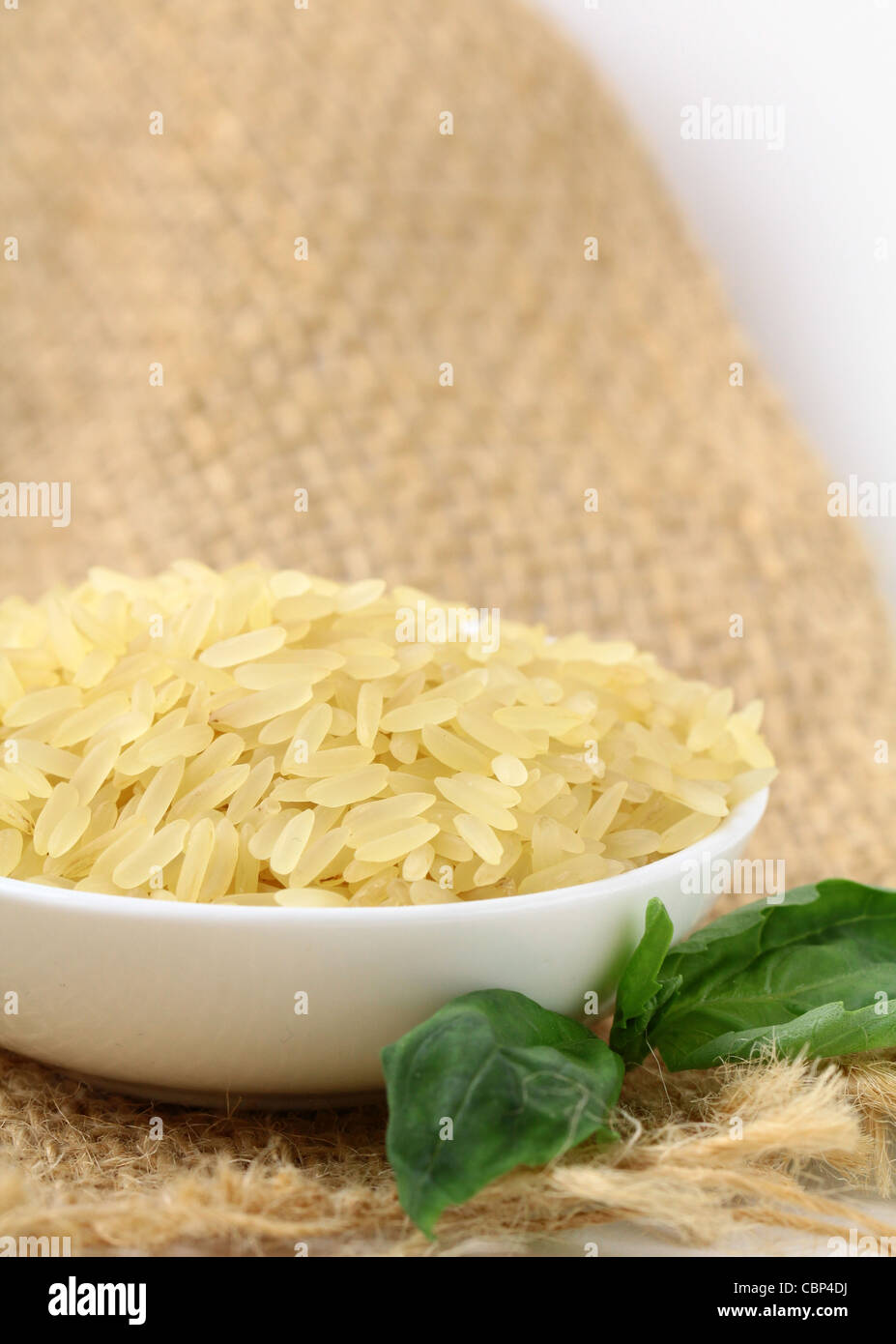 Uncooked rice in white bowl Stock Photo - Alamy