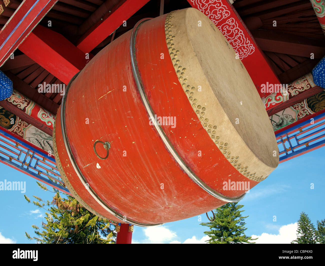 A large Chinese ceremonial drum suspended under a traditional temple ...