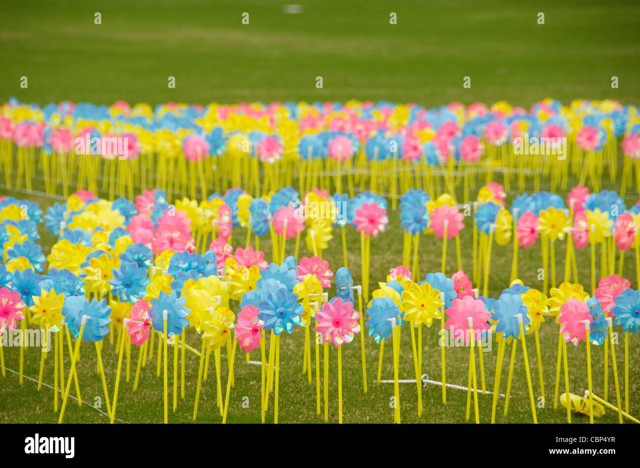 Yellow, blue and red pinwheels on a meadow Stock Photo - Alamy