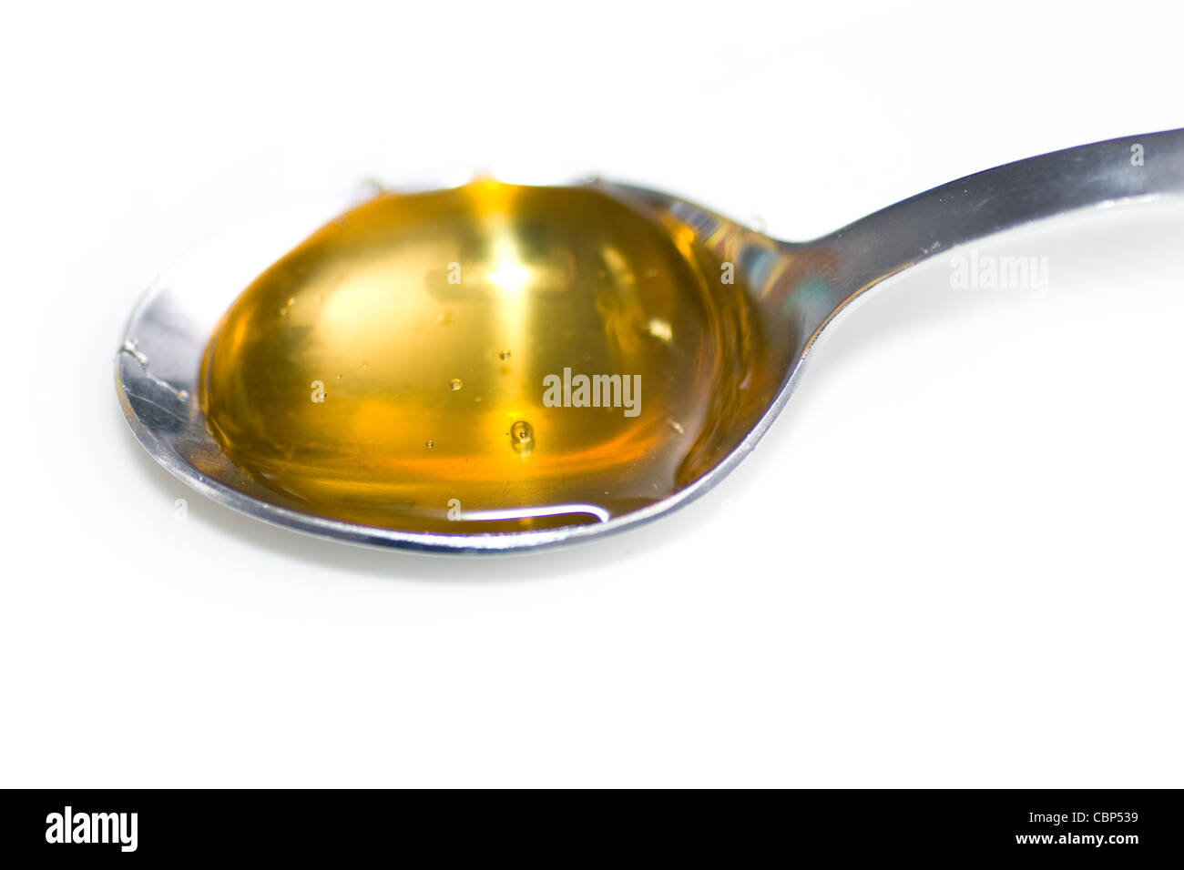 Honey dripping down on spoon Stock Photo - Alamy