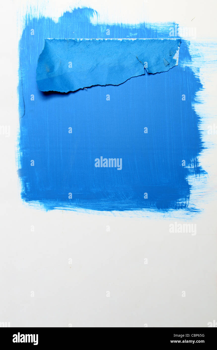 Plastic with blue painting and sheet of damaged paper over the blue ...