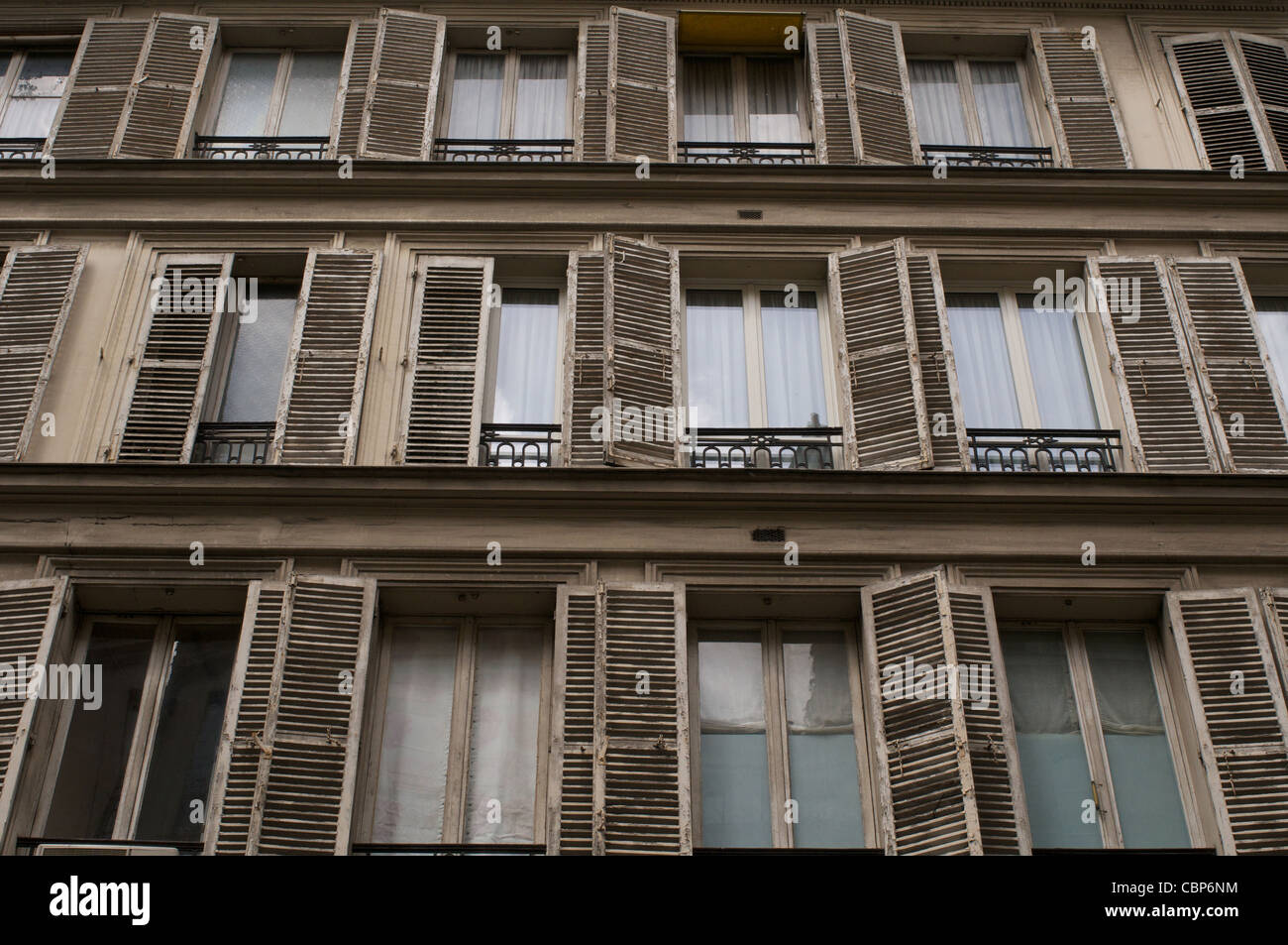 Looking up at traditional apartment windows with the shutters open in ...